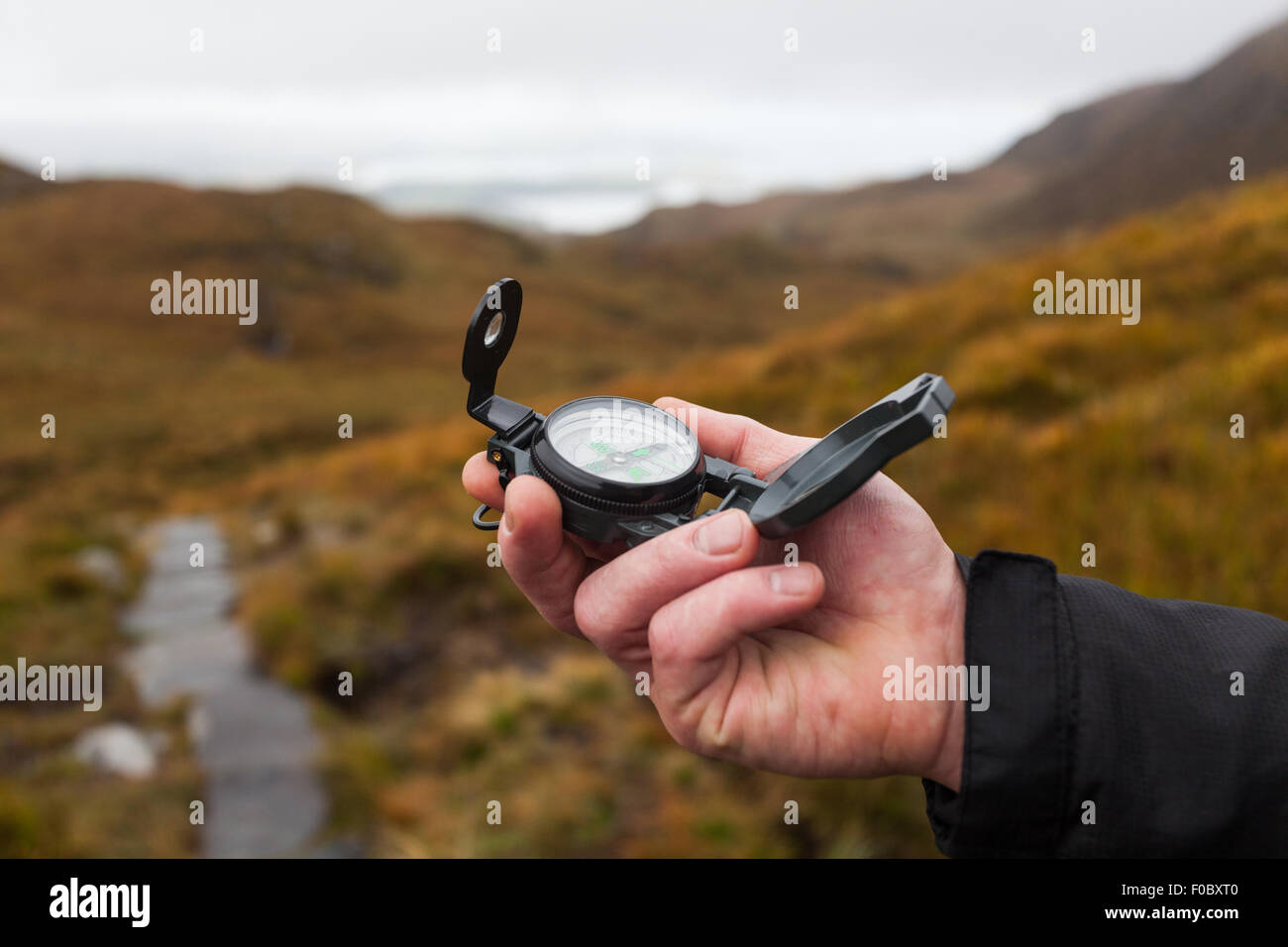 Checking directions with compass in the mountains Stock Photo - Alamy