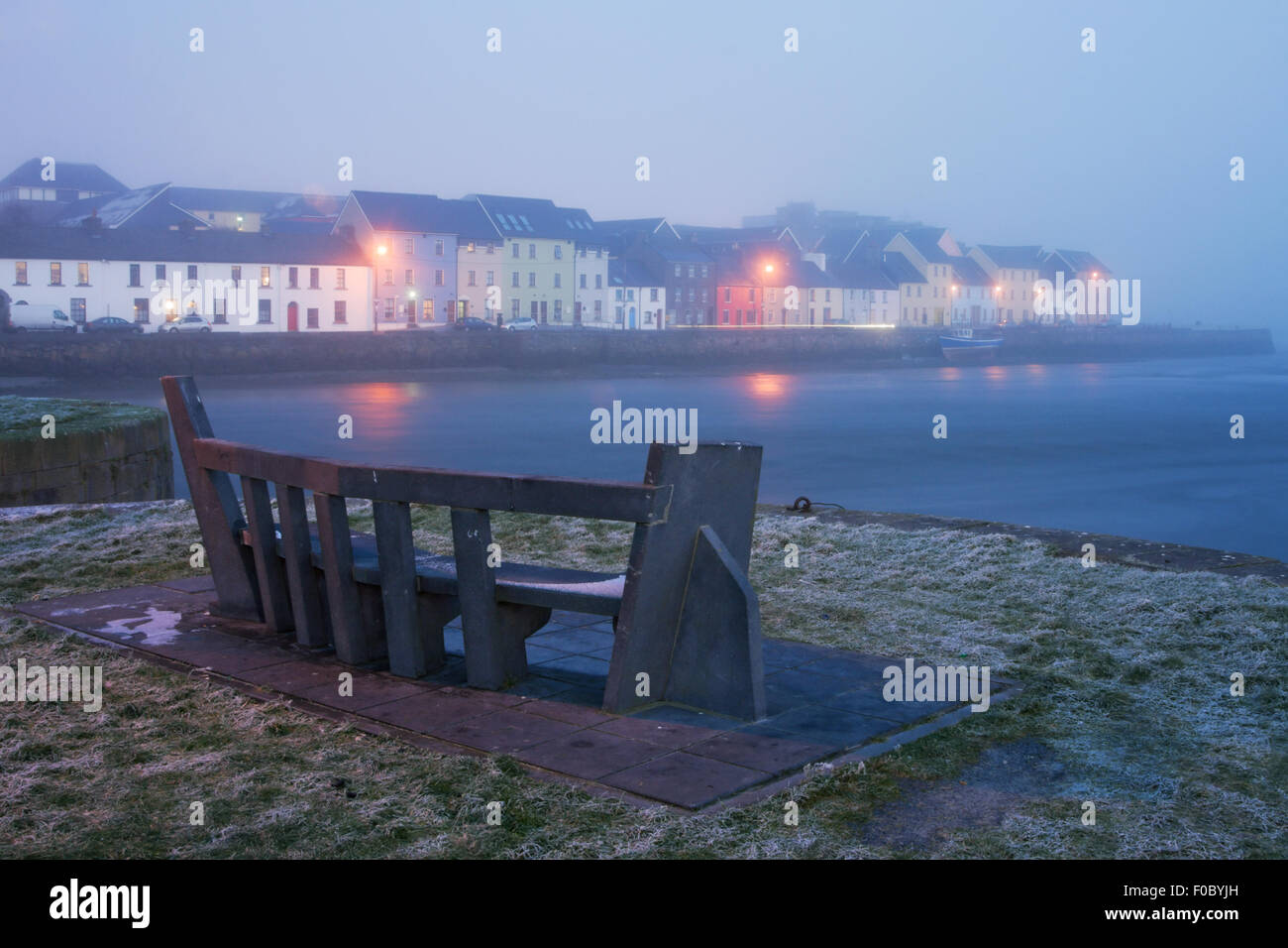 cold night winter view on the Corrib river in fog and houses in Galway ...