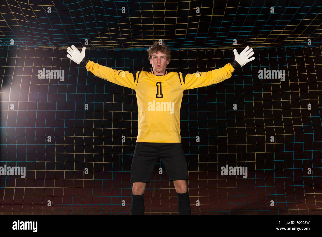 Portrait of confident goalie defending soccer net on field Stock Photo ...