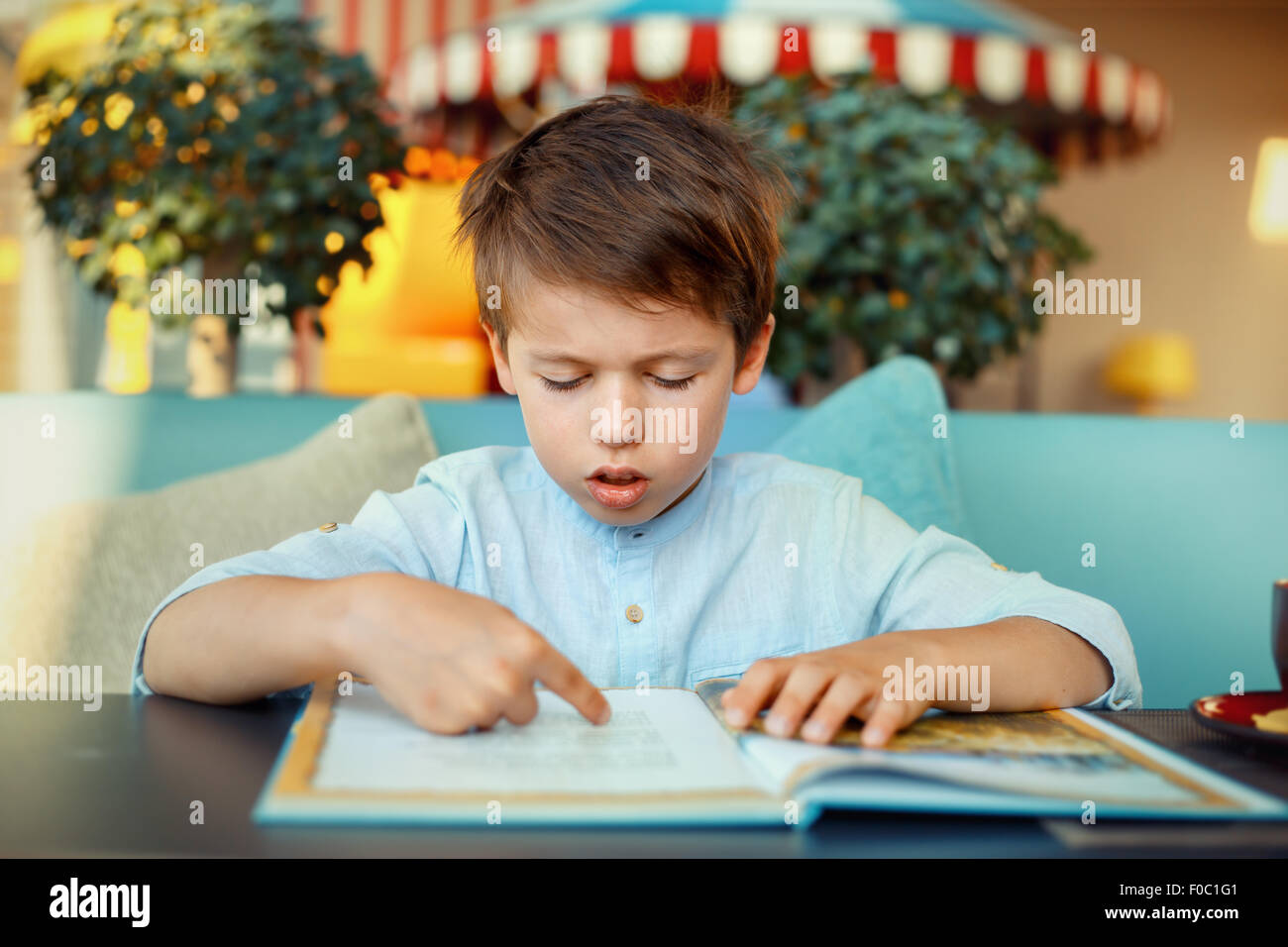 Cute little boy reading book Stock Photo - Alamy