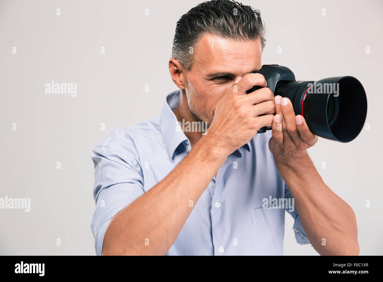 Portrait of a handsome photographer isolated on a white background ...
