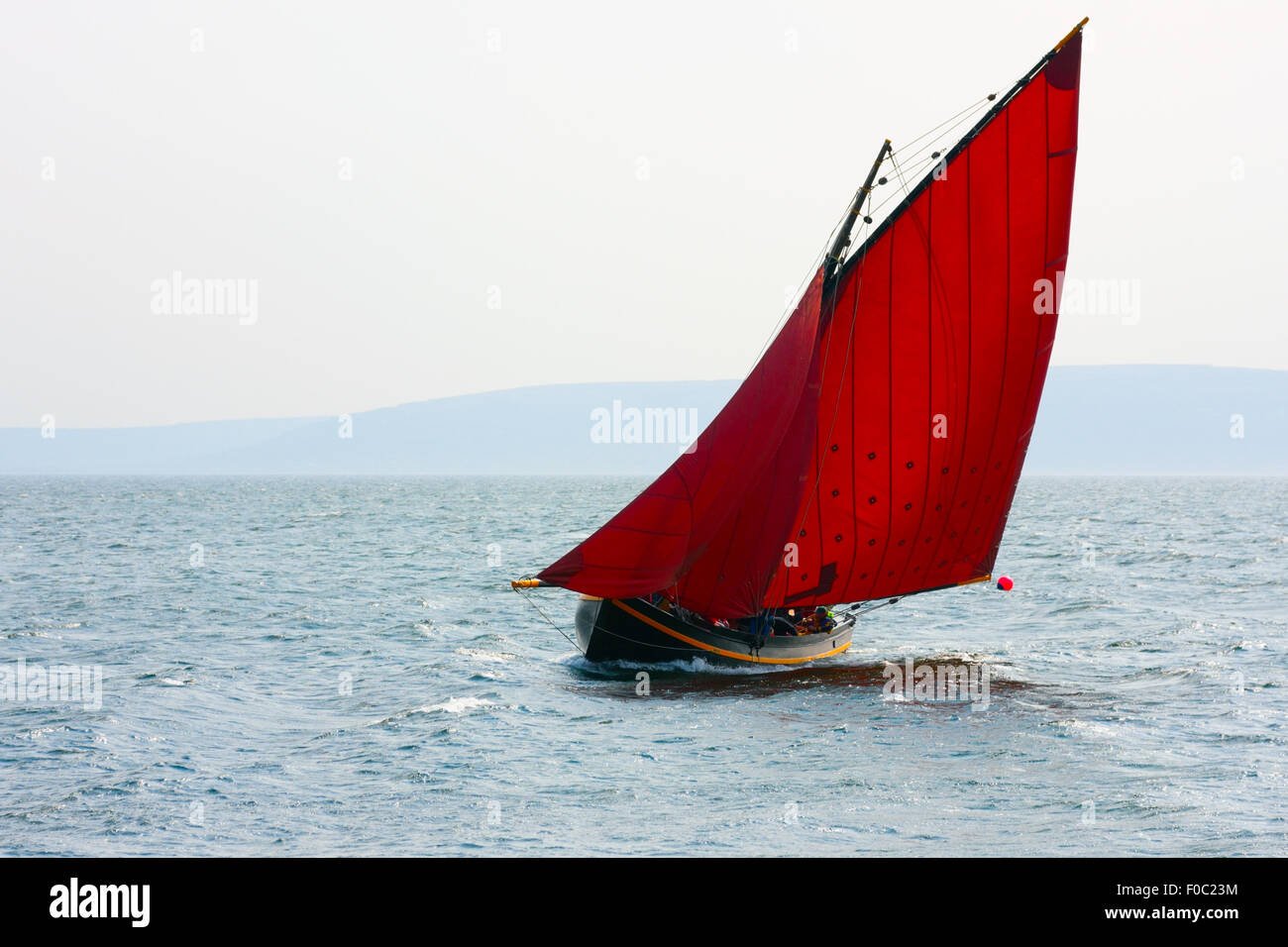 Traditional wooden boats Galway Hooker, with red sail, compete in ...