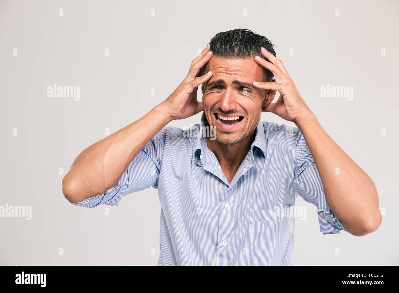 Portrait of a upset businessman standing isolated on a white background ...