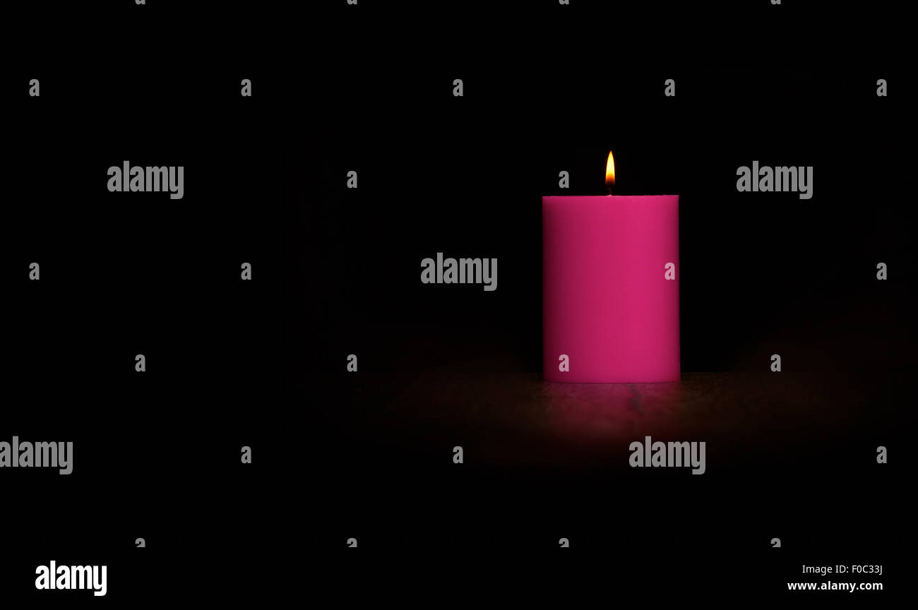Lit red candle on a dark wooden floor with black background Stock Photo ...