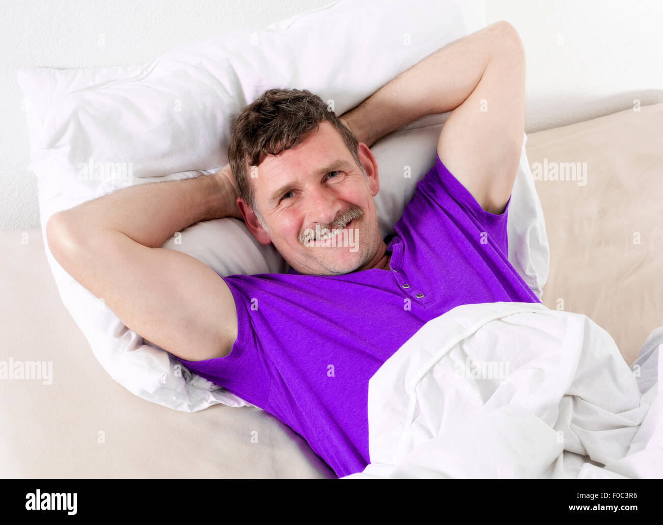 man in bed and smiling Stock Photo - Alamy