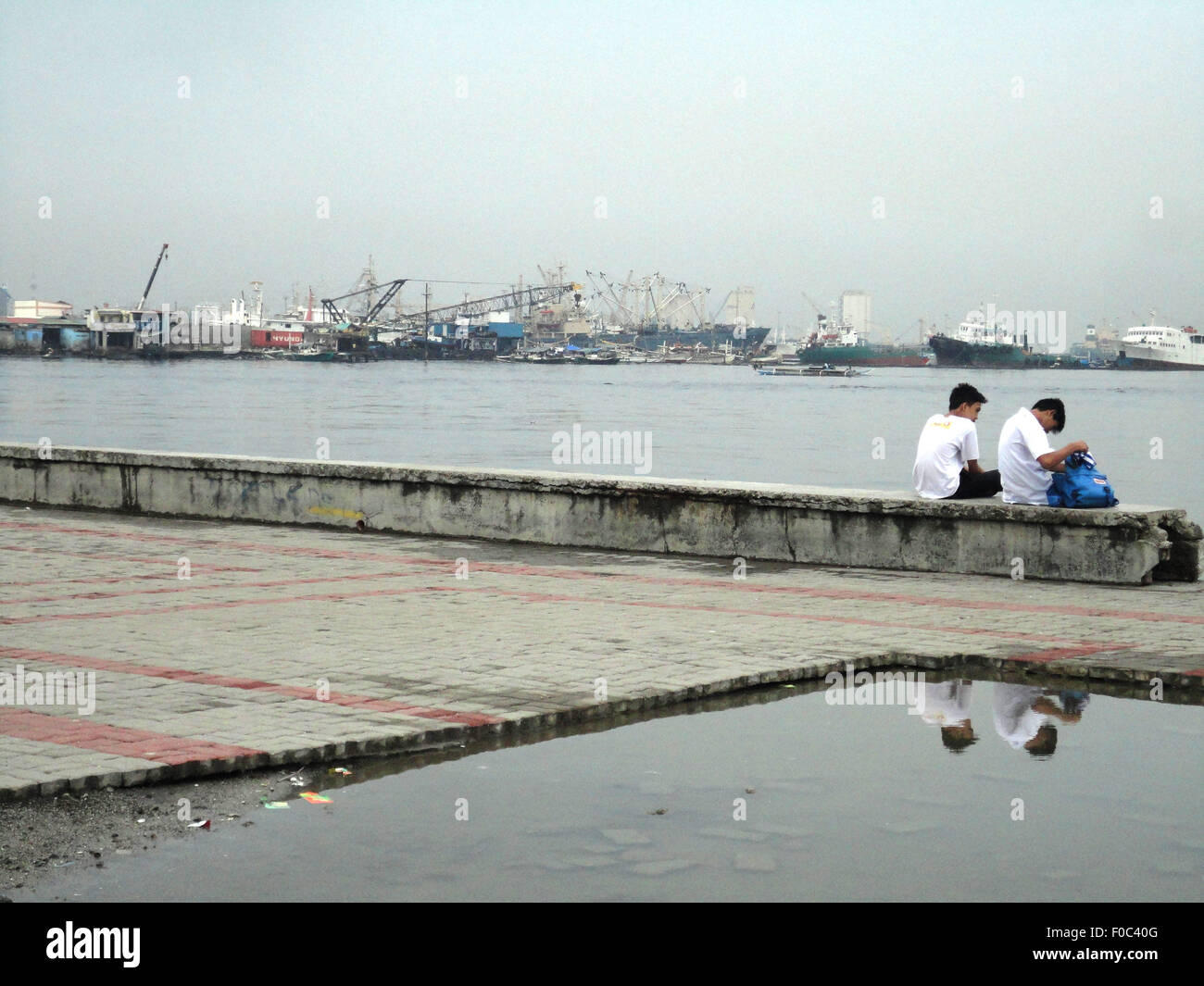 Navotas City, Philippines. 12th Aug, 2015. Filipino students sit along ...