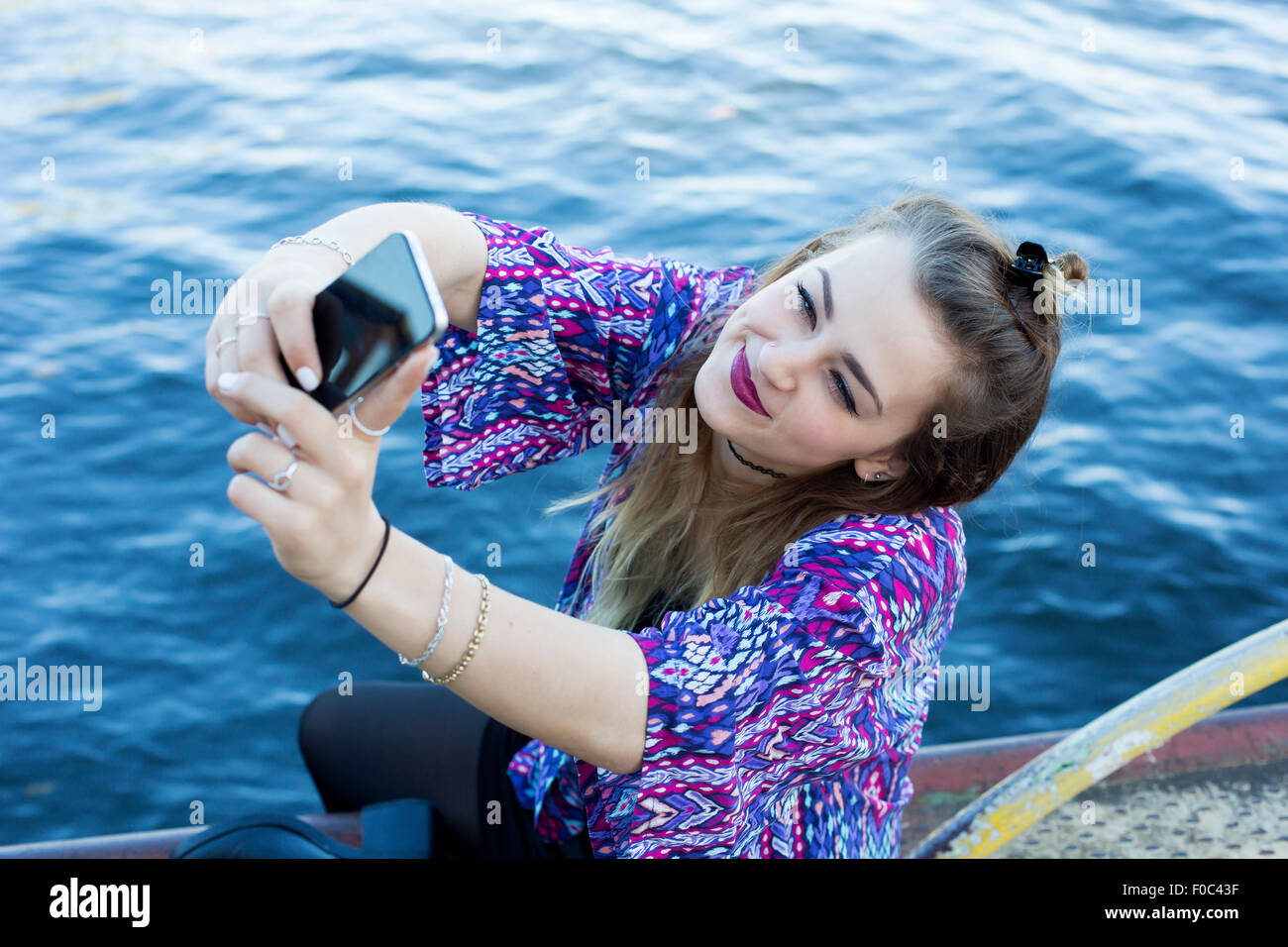 young woman by the waterfront taking a selfie Stock Photo - Alamy