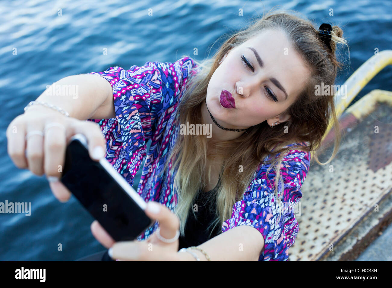 young woman by the waterfront taking a selfie Stock Photo - Alamy