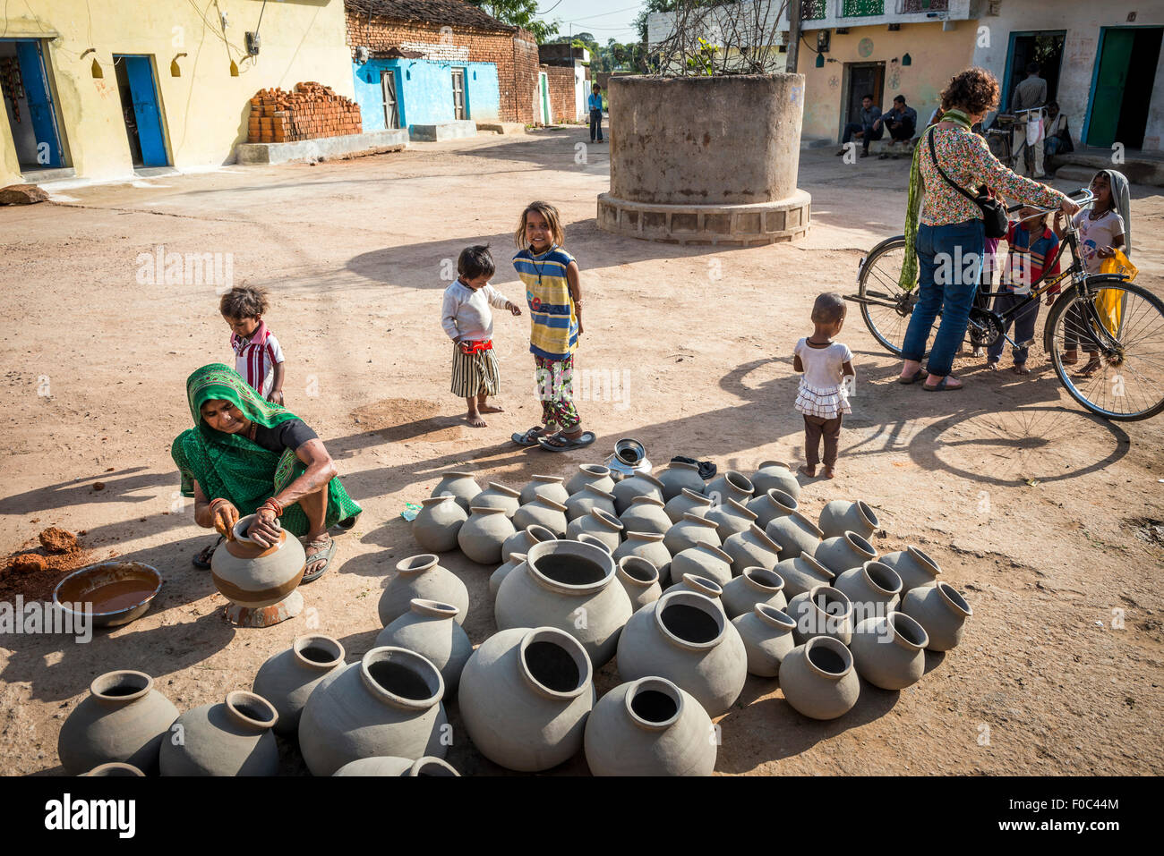Potter's wife decorating traditional pots in the old part of Khajuraho ...
