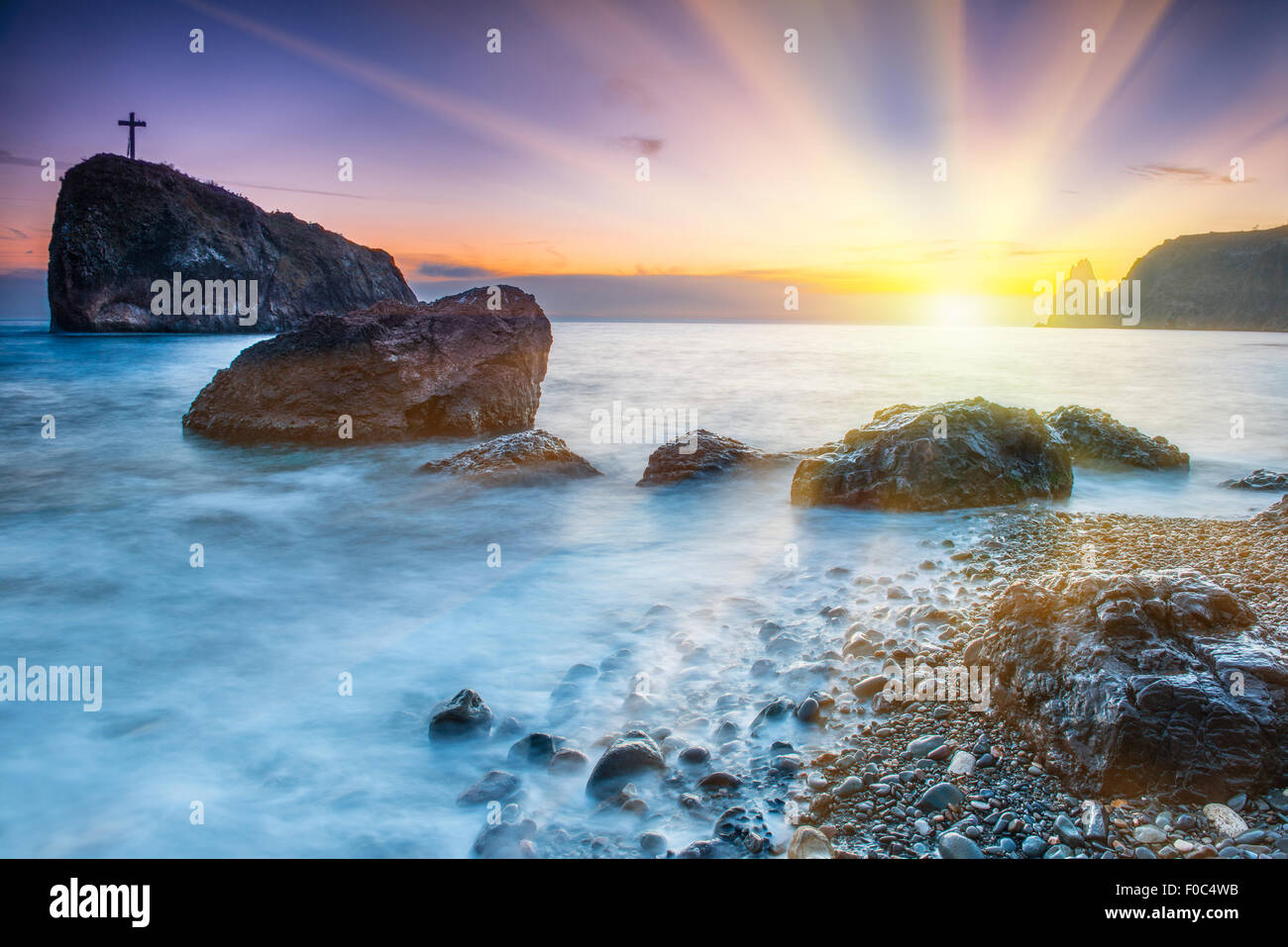 Sunset on the beach with sea, rocks and dramatic sky. Seaside landscape ...