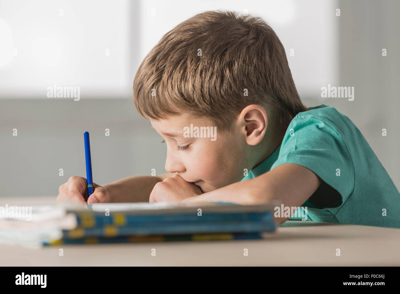 Side view of boy doing homework at home Stock Photo - Alamy