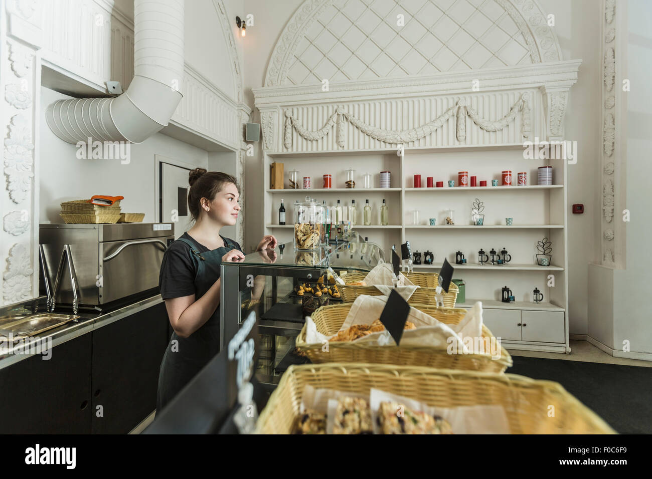Woman standing behind counter hi-res stock photography and images - Alamy