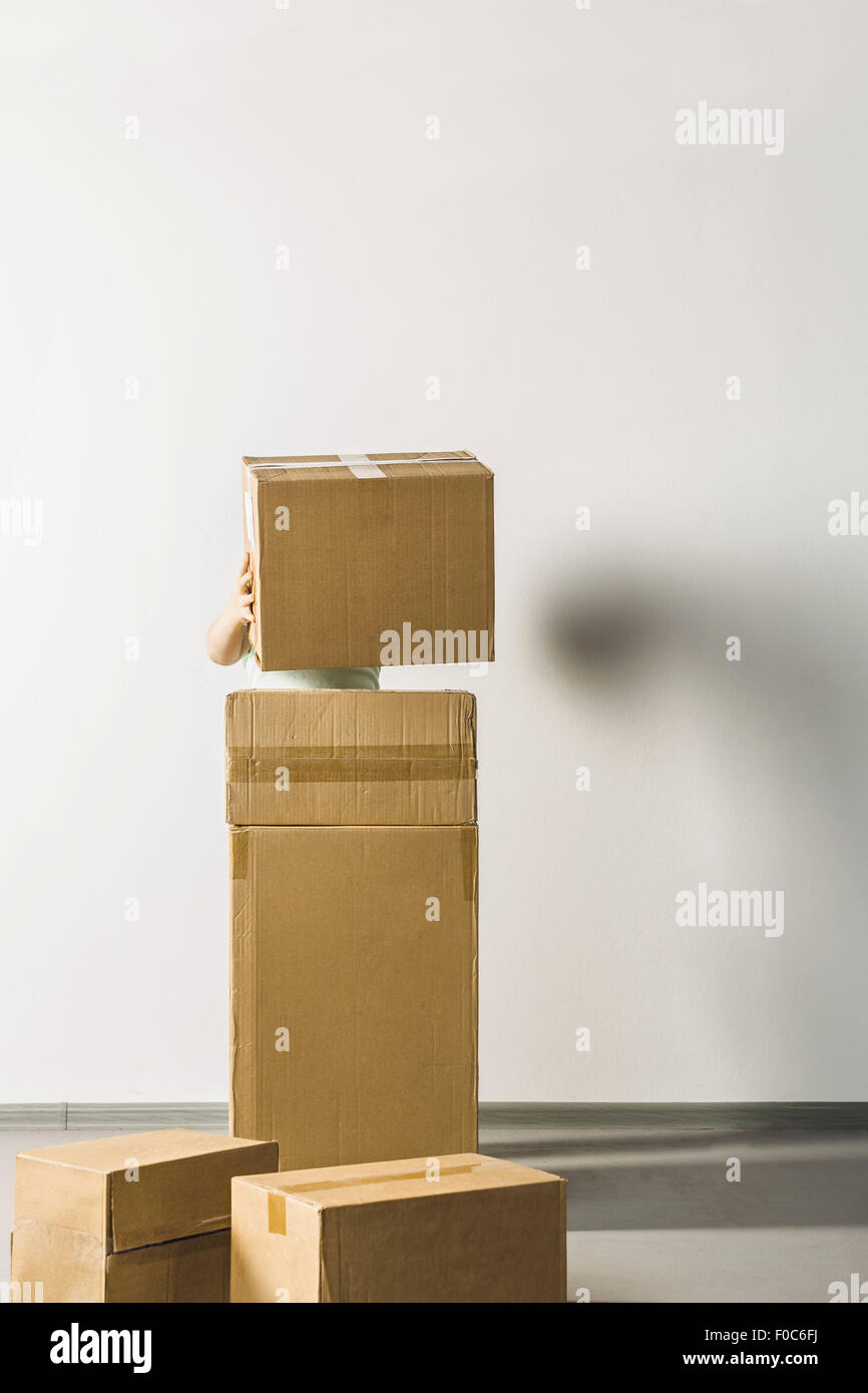 Full length side view of girl stacking boxes in house Stock Photo - Alamy