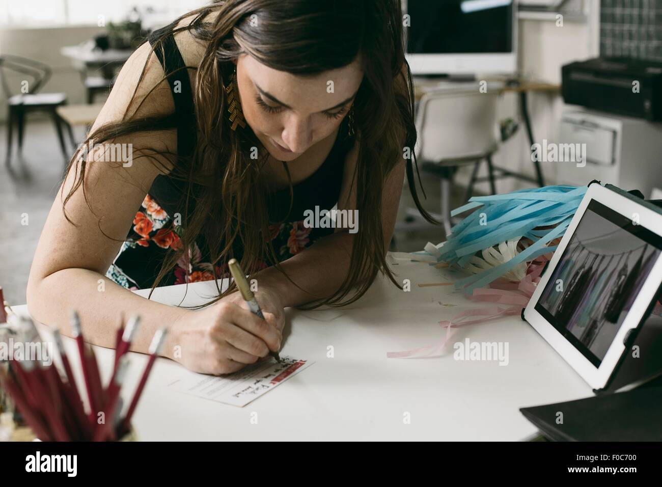 Female designer making note in design studio Stock Photo - Alamy
