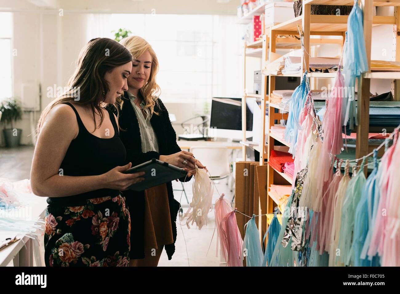 Two female designers using digital tablet in design studio Stock Photo ...