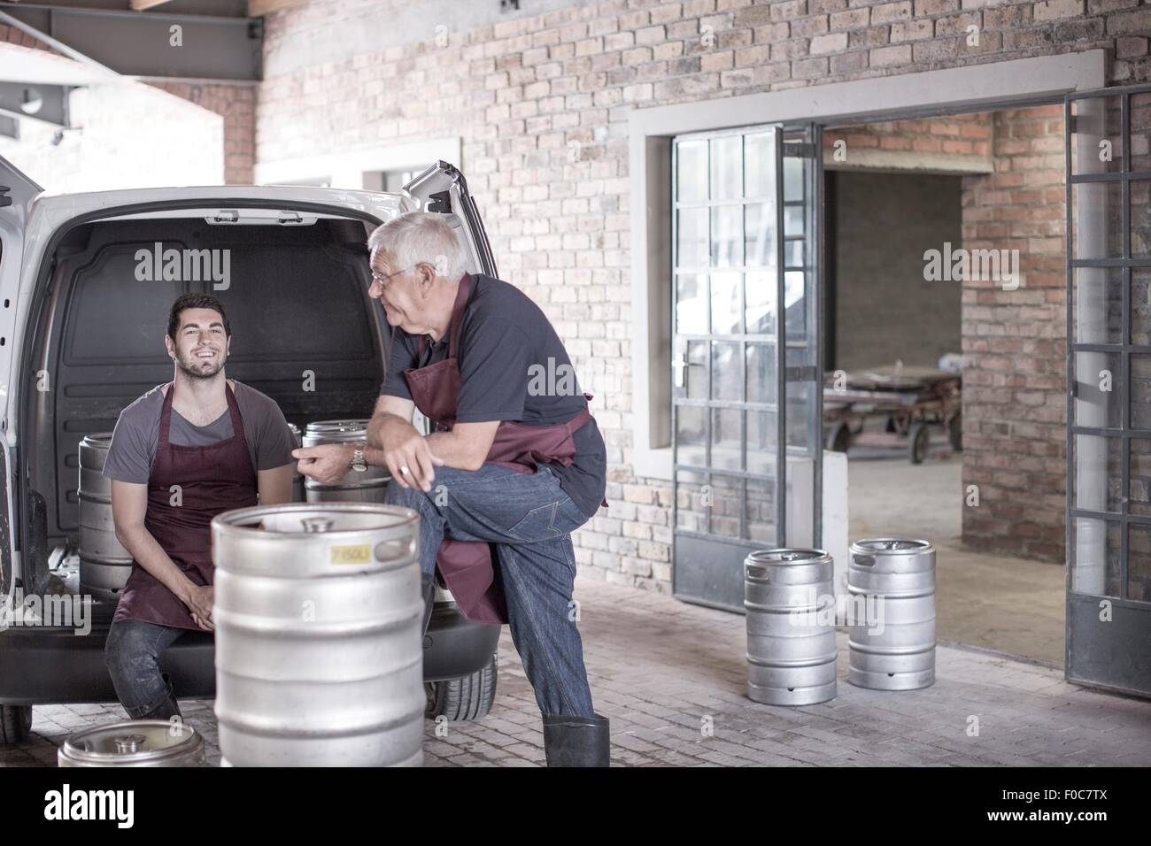 Brewers loading kegs into back of van Stock Photo - Alamy