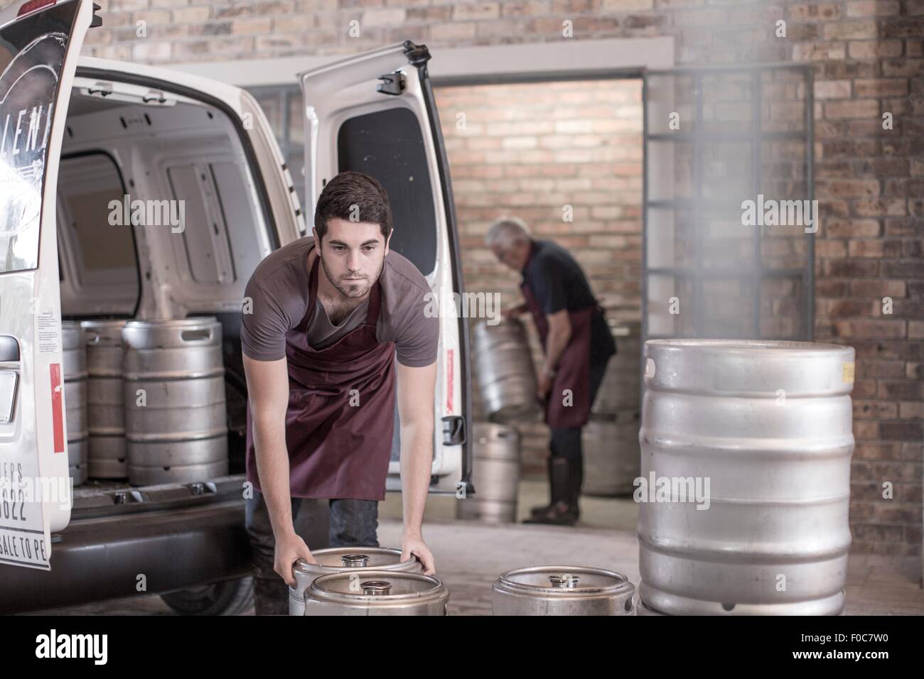 Brewers loading kegs into back of van Stock Photo - Alamy