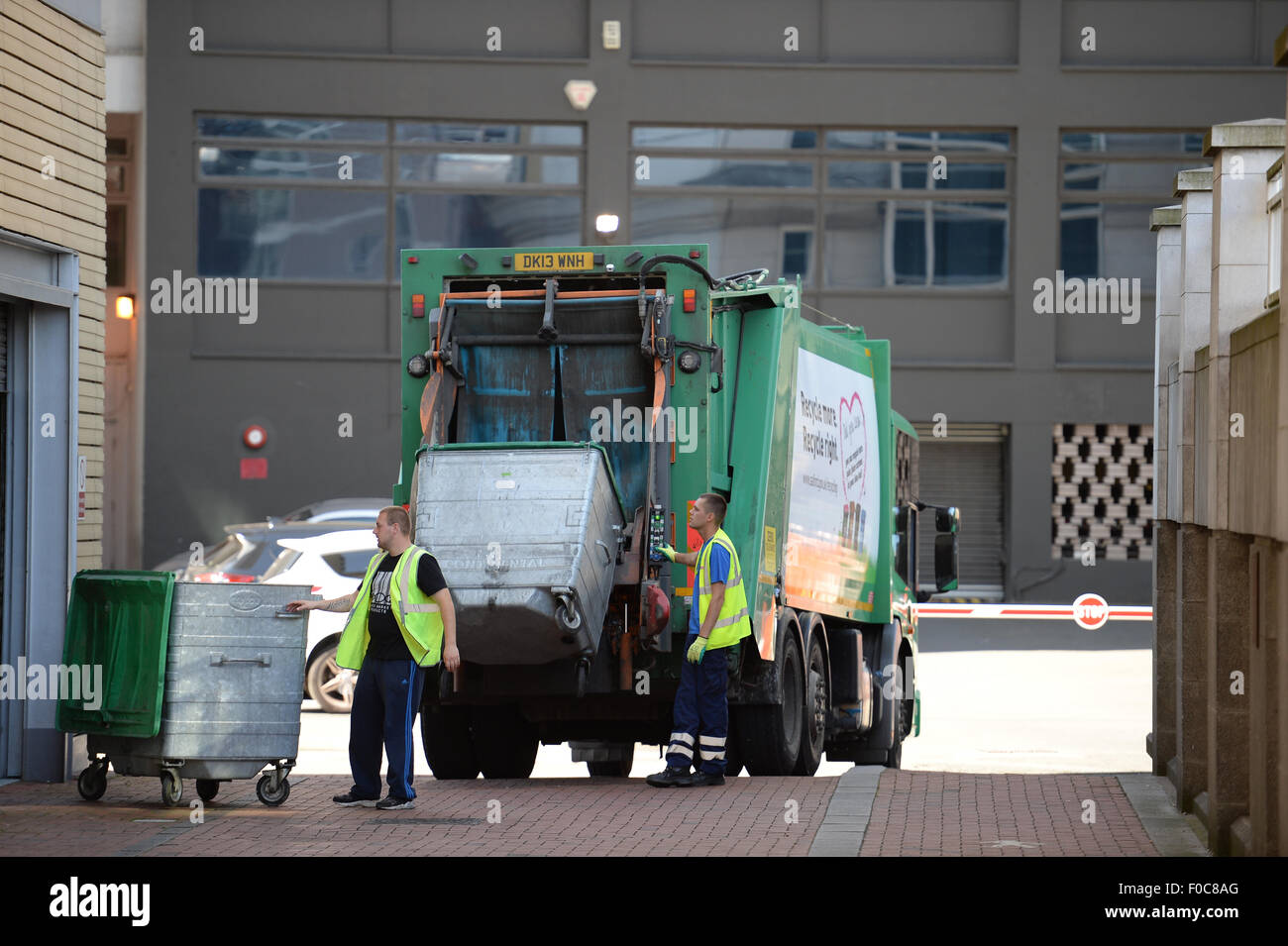Refuse collectors emptying industrial wheelie bins in Manchester City ...