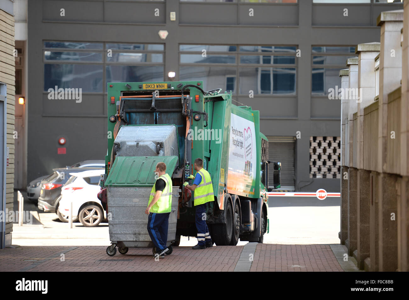 Refuse collectors emptying industrial wheelie bins in Manchester City ...