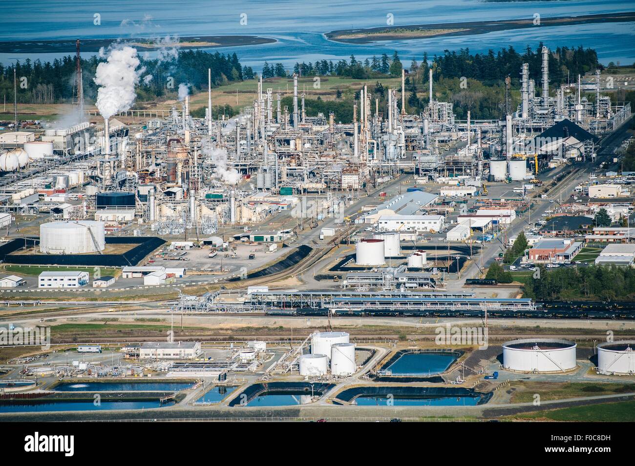 High angle view of oil storage tanks and smoke stack in coastal oil ...