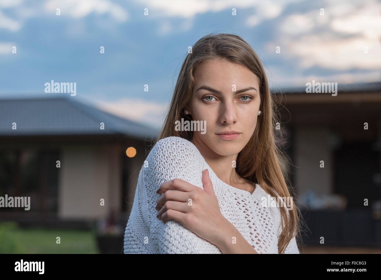 Portrait of beautiful young woman hugging self outdoors Stock Photo - Alamy
