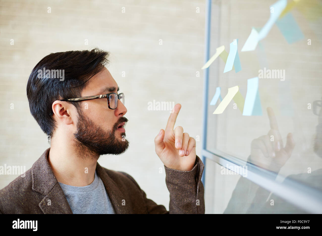 Attractive businessman pointing at notepaper on board Stock Photo - Alamy