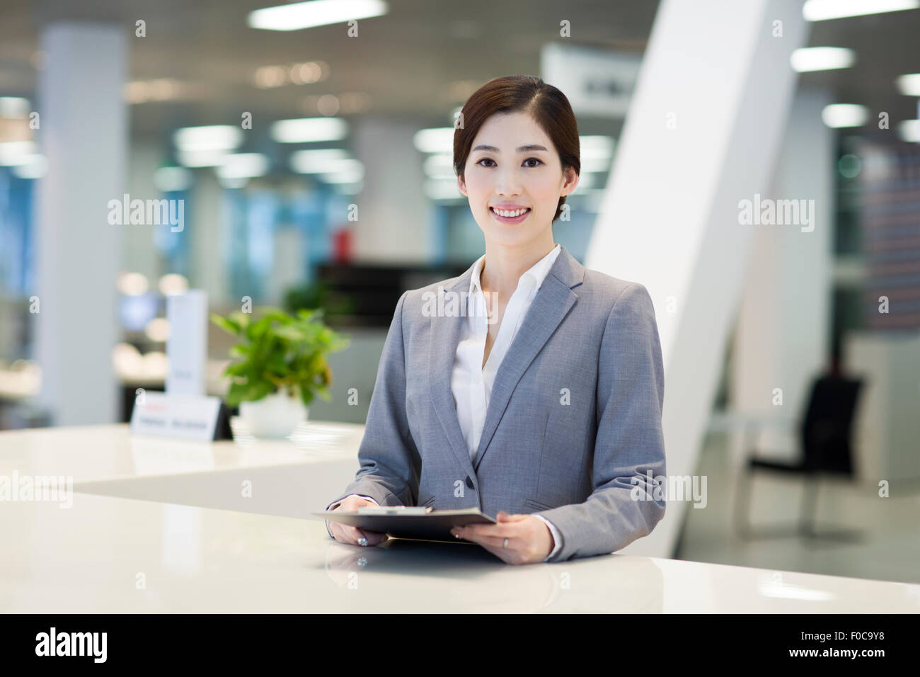 Confident receptionist at reception counter Stock Photo - Alamy