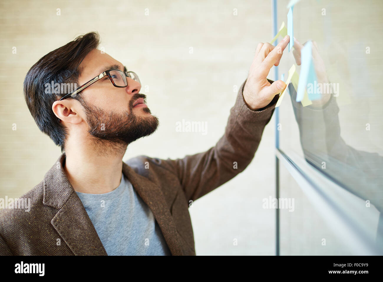 Young businessman reading note on sticker Stock Photo - Alamy