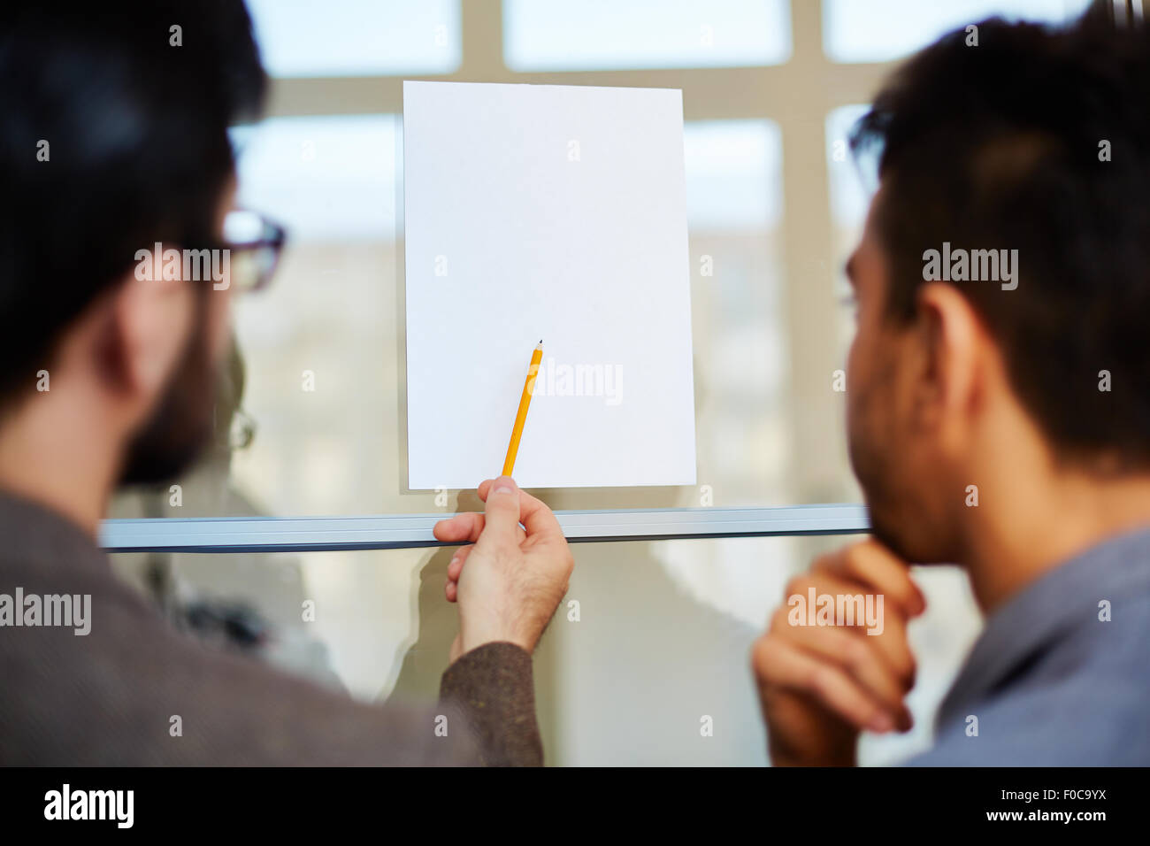 Businessman pointing at blank paper at meeting Stock Photo - Alamy