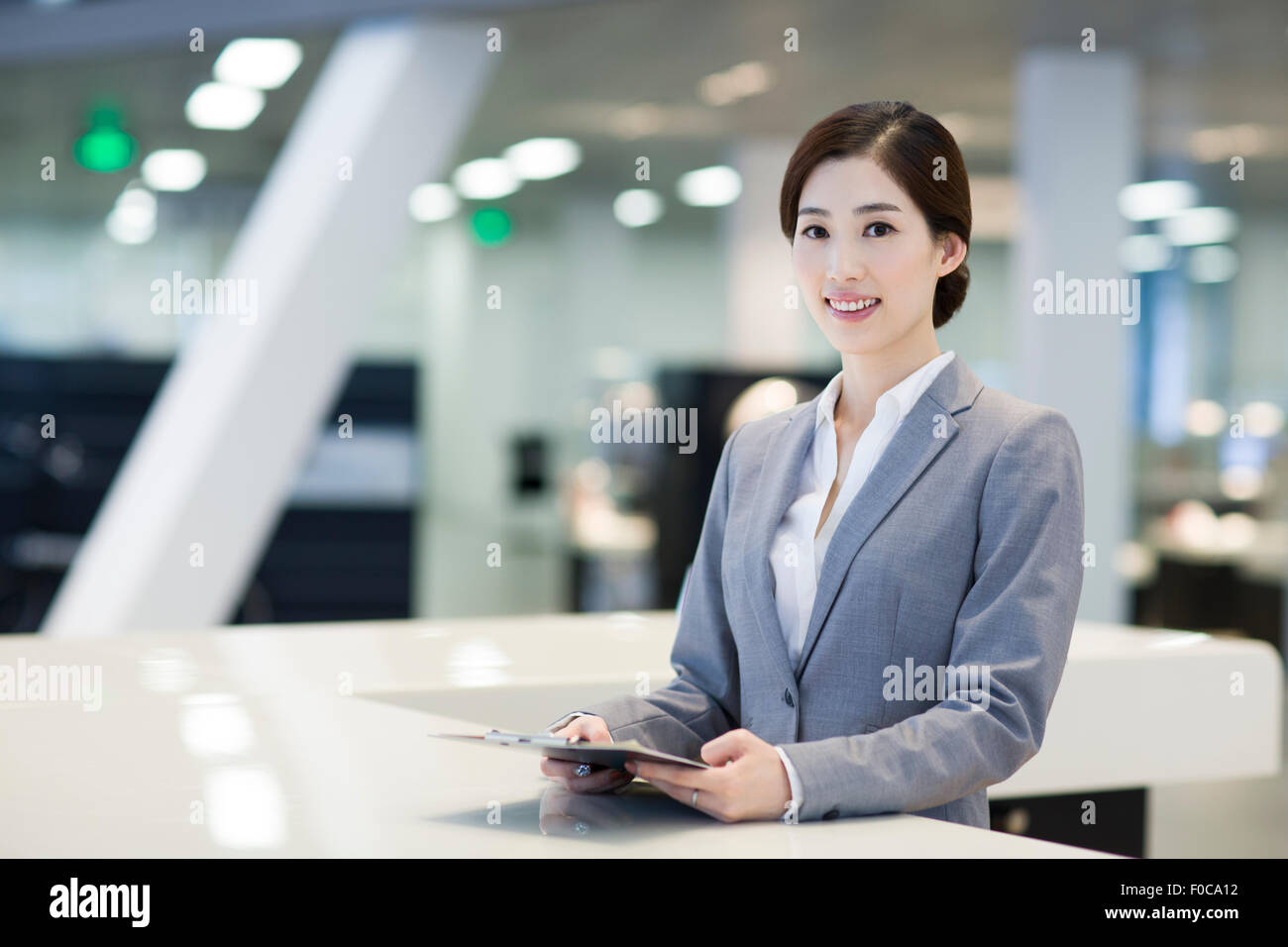 Confident receptionist at reception counter Stock Photo - Alamy