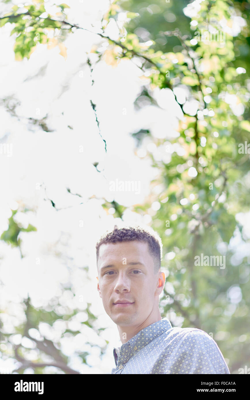 Low angle portrait of young man in park Stock Photo - Alamy