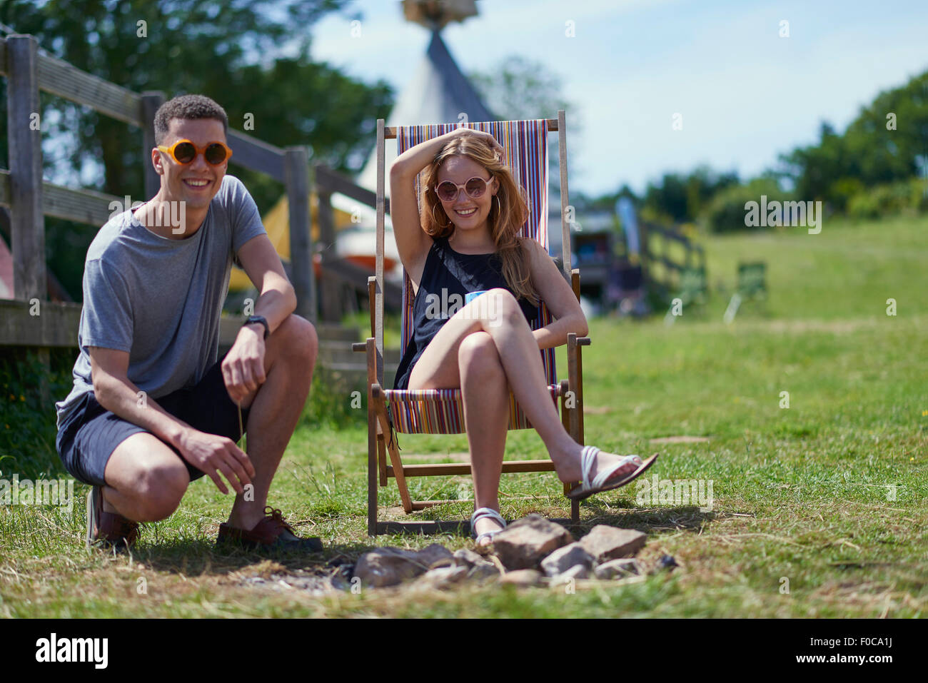 Portrait of happy couple glamping, teepee in background Stock Photo - Alamy