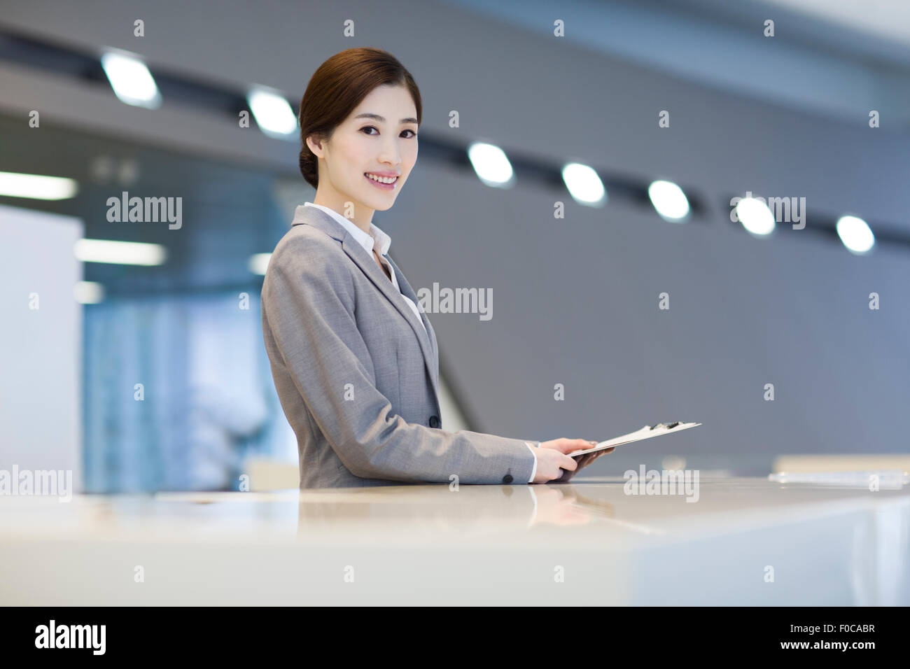 Confident receptionist at reception counter Stock Photo - Alamy
