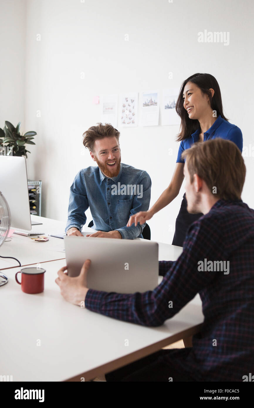Happy business people communicating at desk in office Stock Photo - Alamy