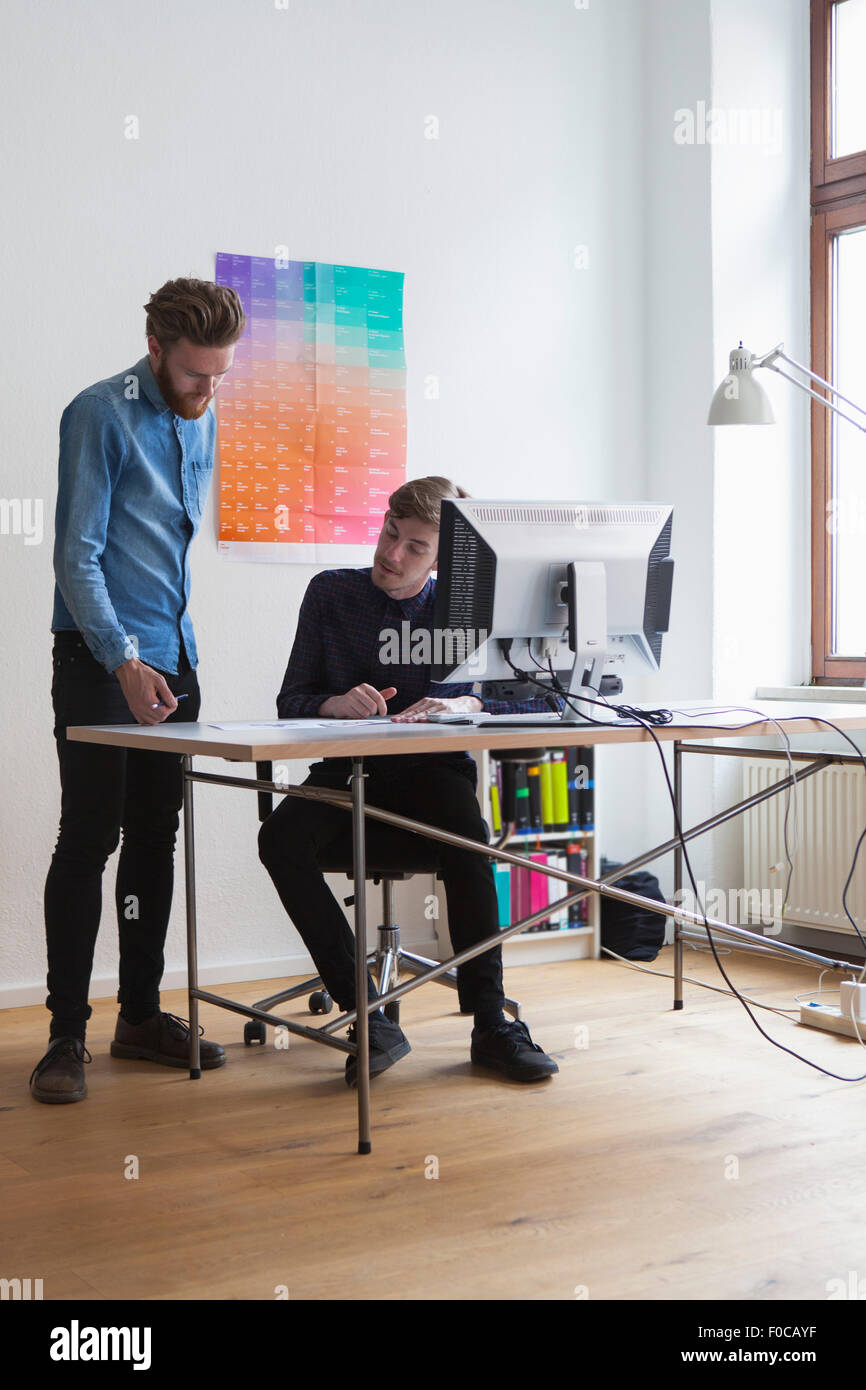 Businessmen discussing at desk in office Stock Photo - Alamy