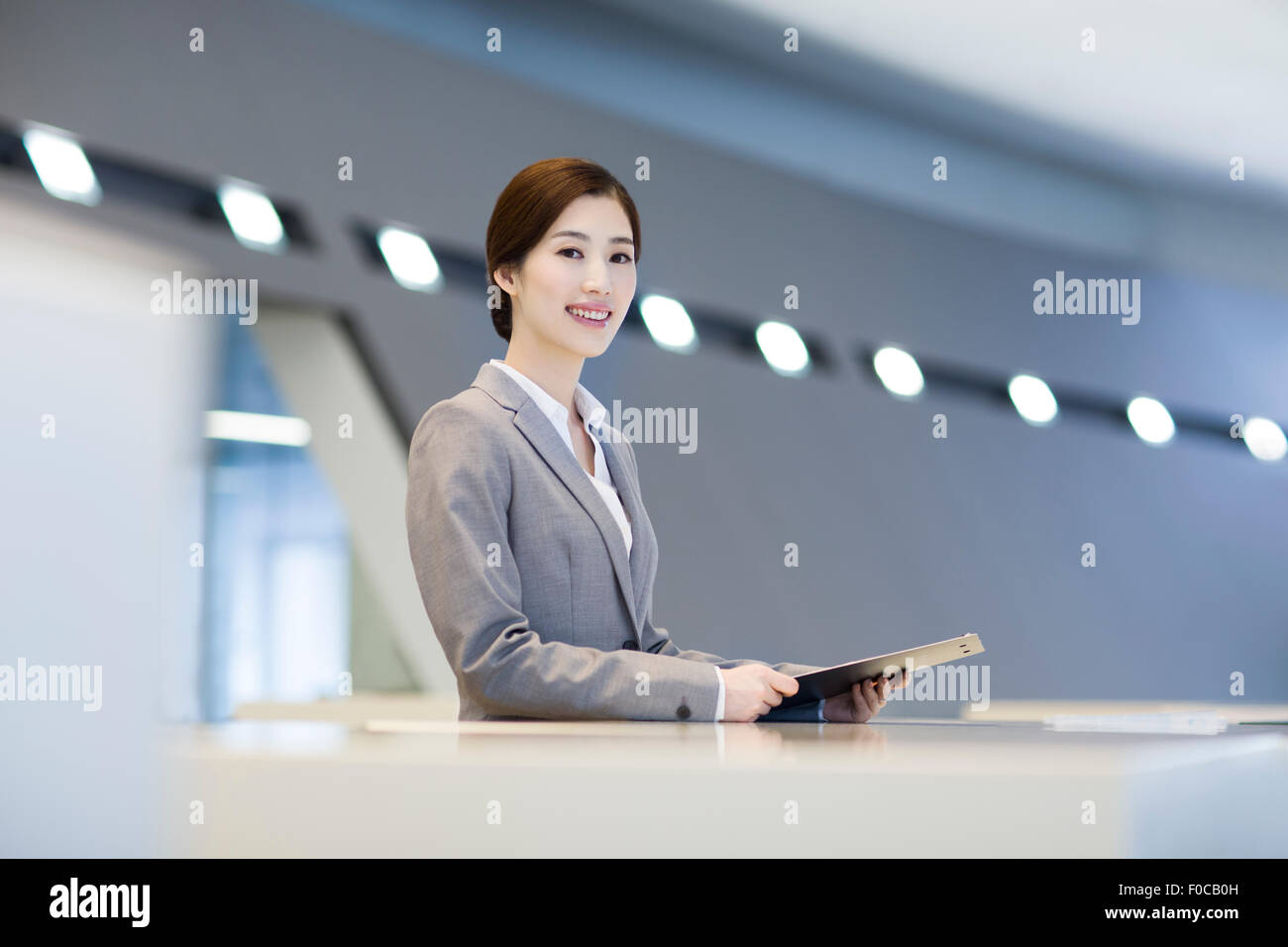 Confident receptionist at reception counter Stock Photo - Alamy