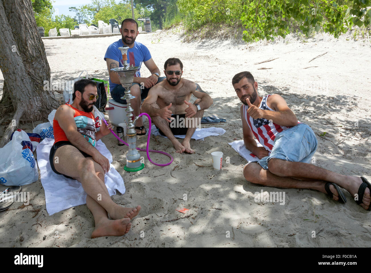 Four young men smoking water pipe at Wasaga Beach Provincial Park in ...