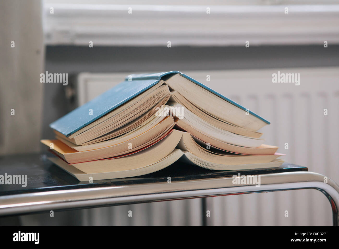 Close-up of stacked open books on table Stock Photo - Alamy