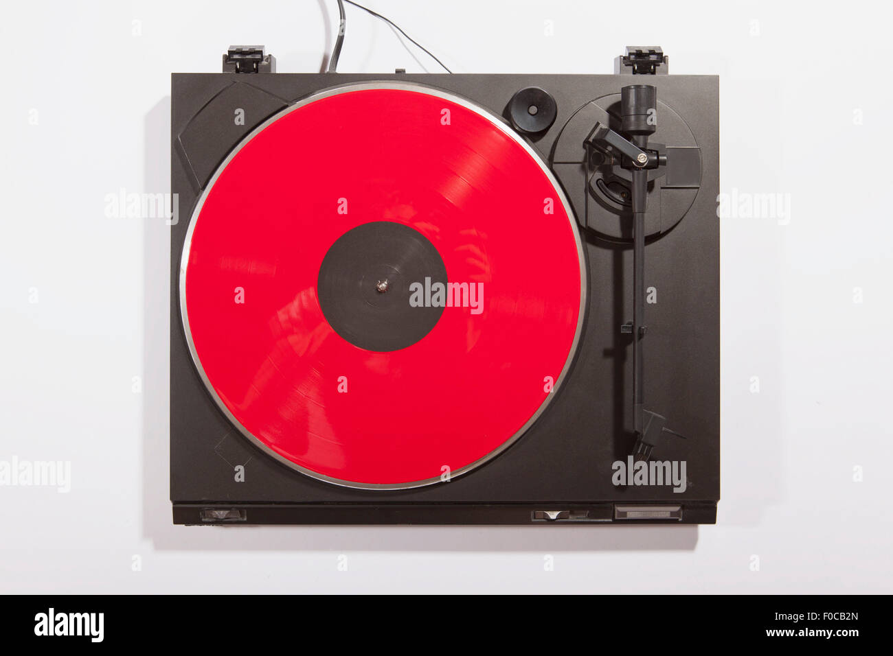 Red record playing on turntable on white background Stock Photo - Alamy