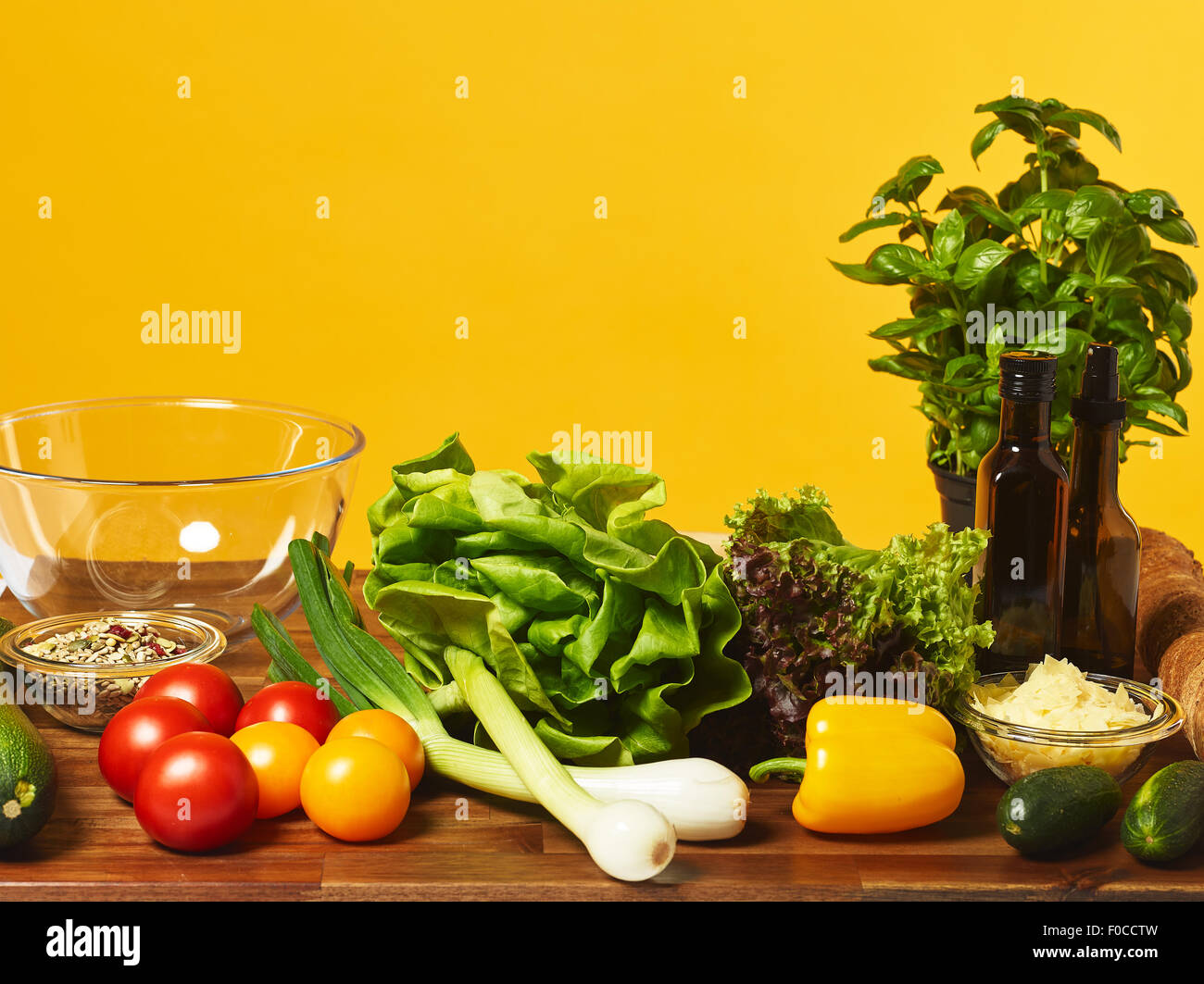 Fresh salad ingredients on the table, copy space and yellow background ...