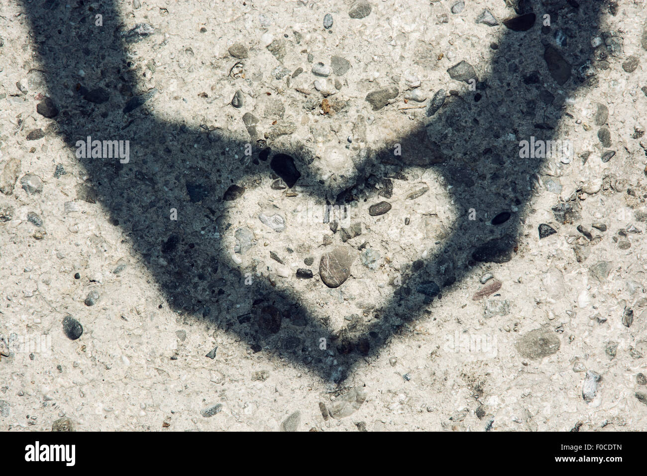 Young woman makes heart shadow with her hands at the stone paving Stock ...