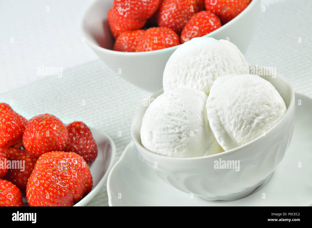 close up of a white bowl with vanilla ice cream and strawberries, macro ...
