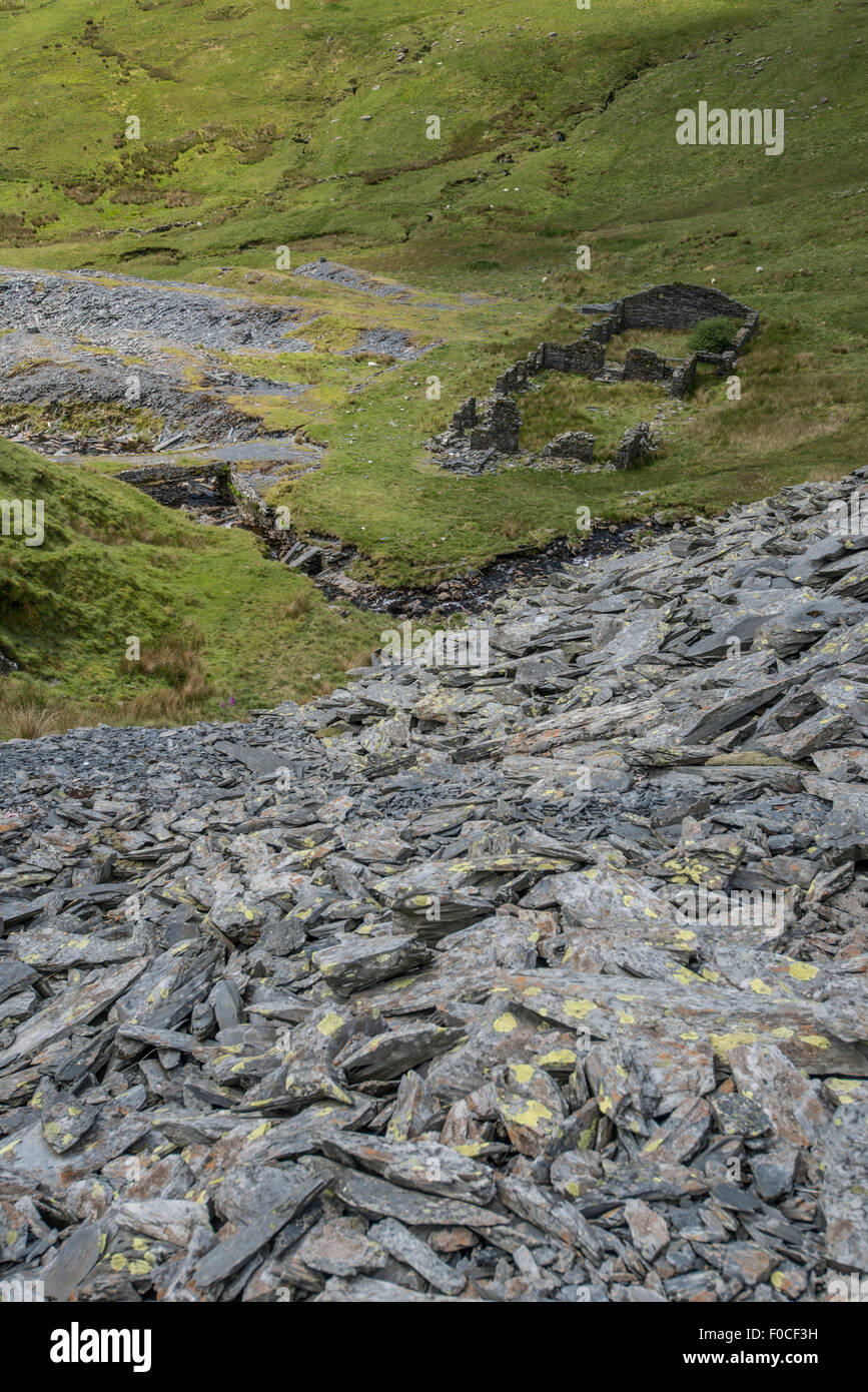 Remains of old slate mine, with spoil heap in foreground. Snowdonia ...
