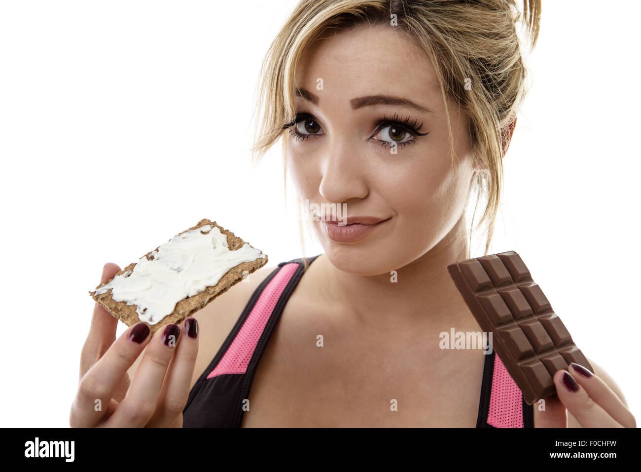 fitness woman holding a chocolate bar and a healthy crispbread snack ...