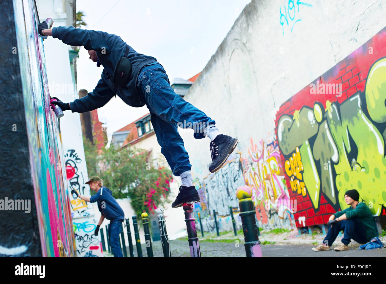 Boys painting graffiti on the wall in Lisbon Stock Photo - Alamy