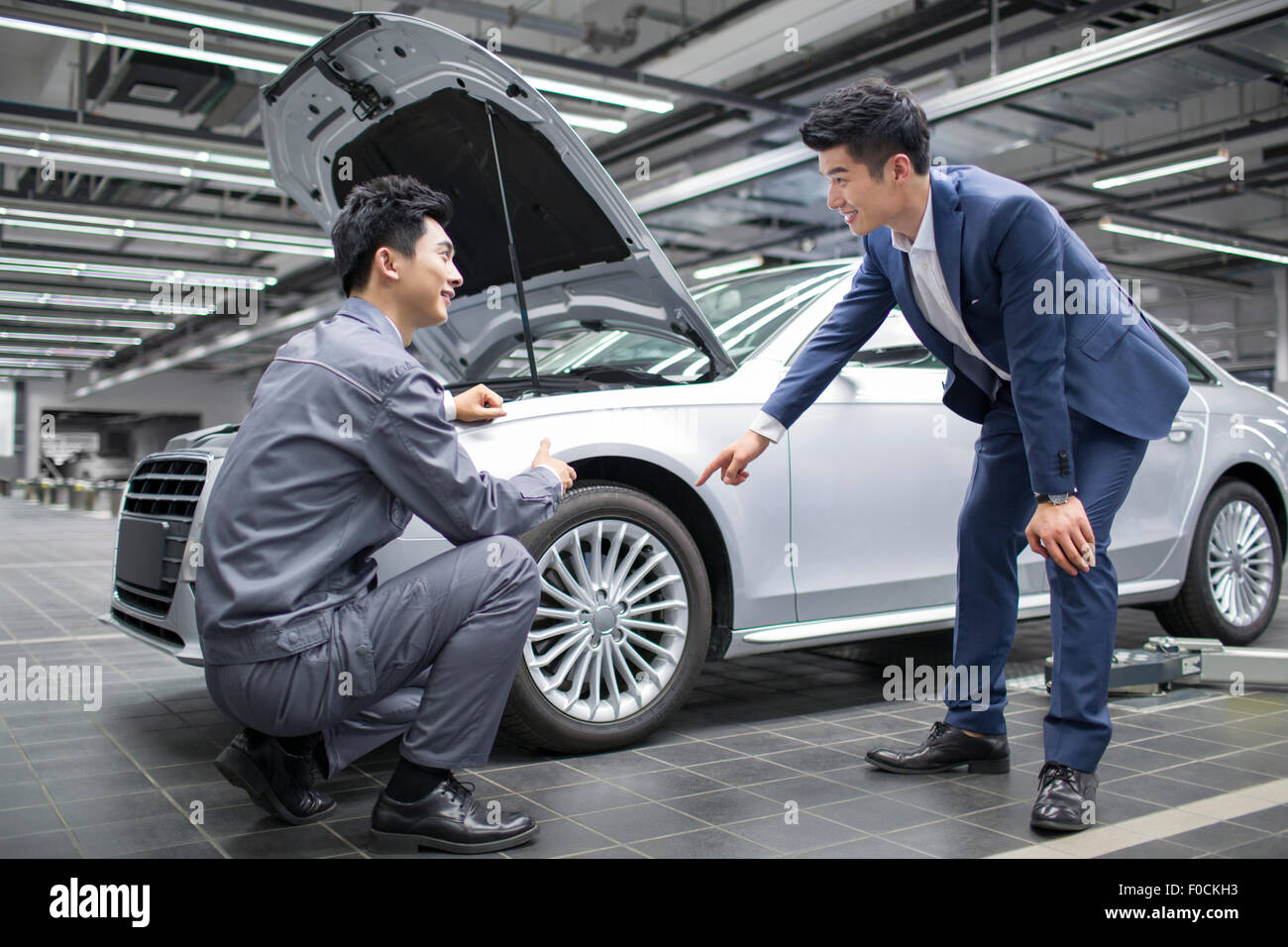 Auto mechanic talking with car owner Stock Photo - Alamy