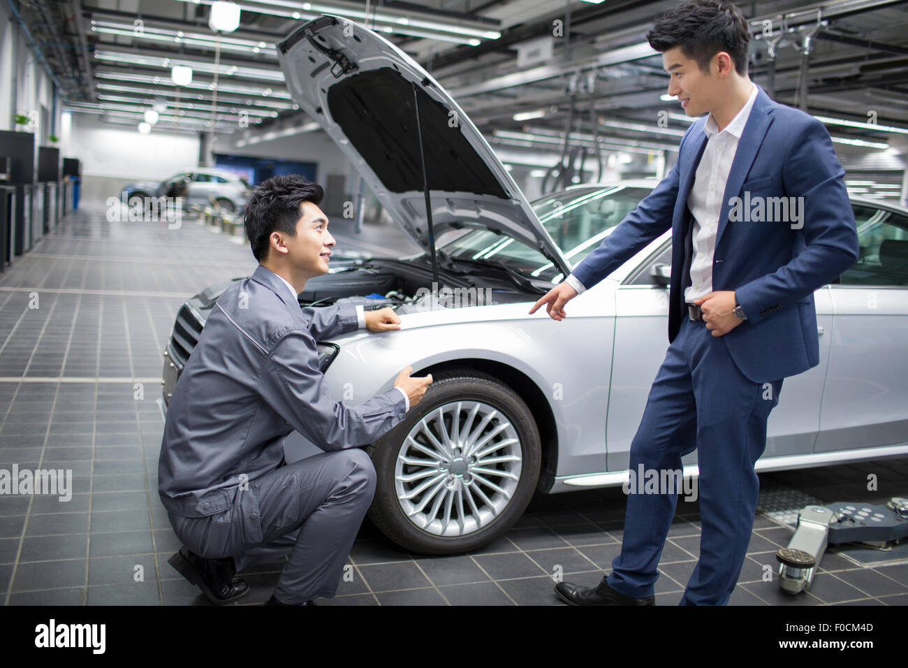 Auto mechanic talking with car owner Stock Photo - Alamy
