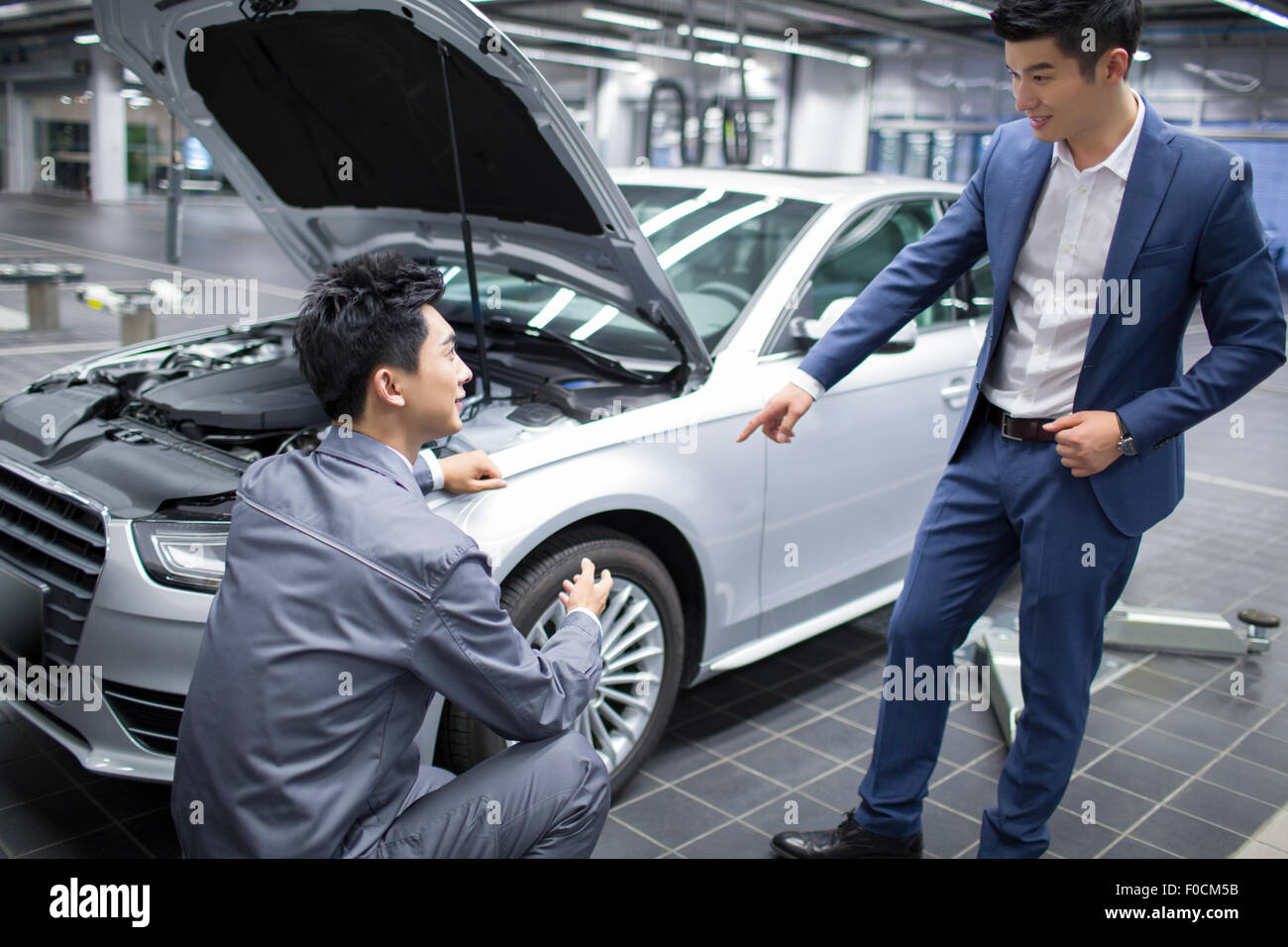 Auto mechanic talking with car owner Stock Photo - Alamy