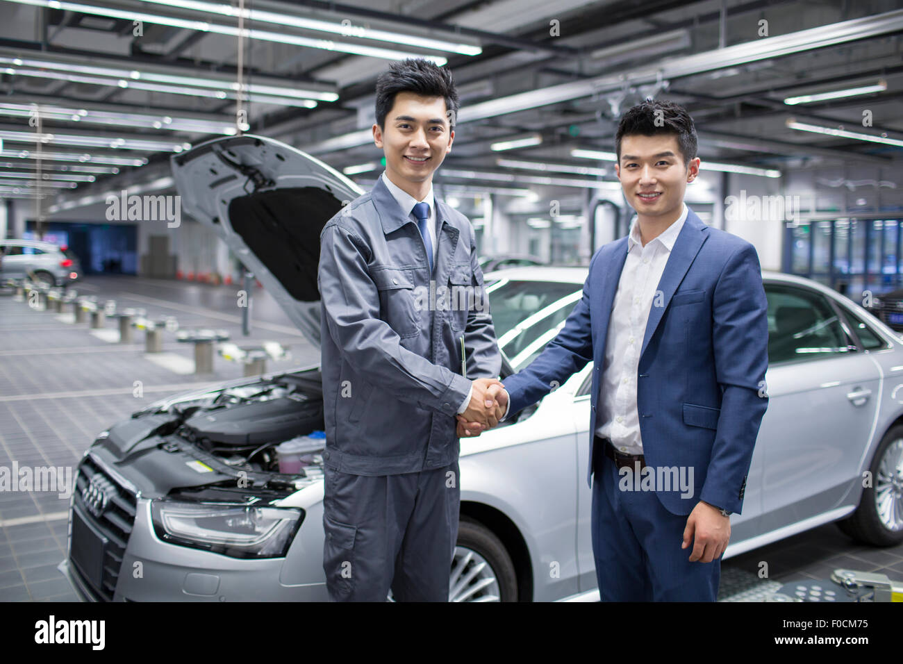 Auto mechanic and car owner shaking hands Stock Photo - Alamy