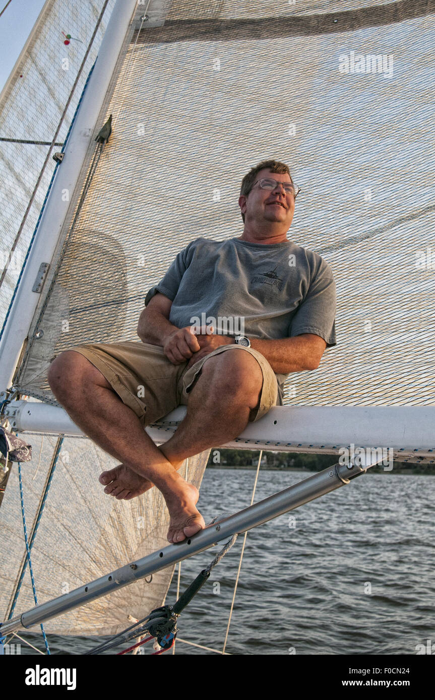 Man sitting on the sail structure of his sailboat. He is content Stock ...